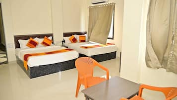Quarto de hotel com duas camas, uma mesa e uma cadeira.