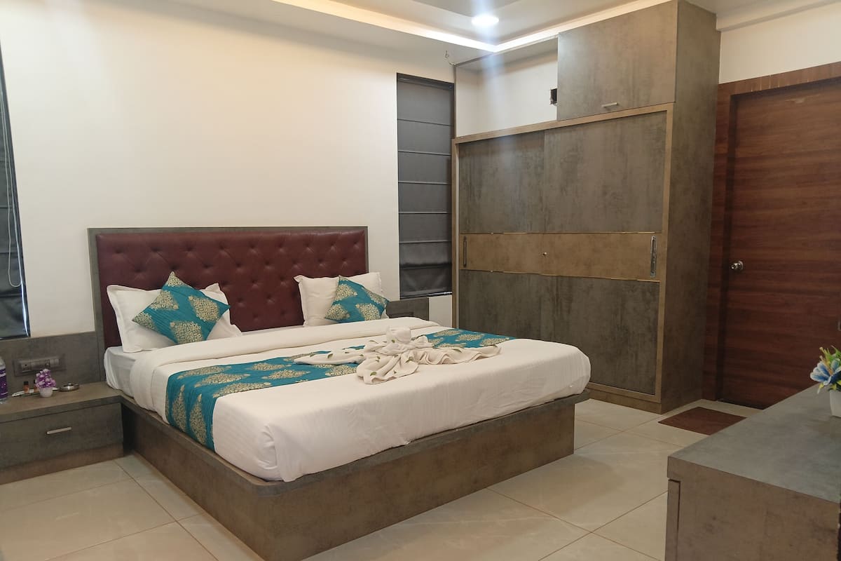 Quarto bem arrumado com uma cama grande, um guarda-roupa e uma mesa de cabeceira.