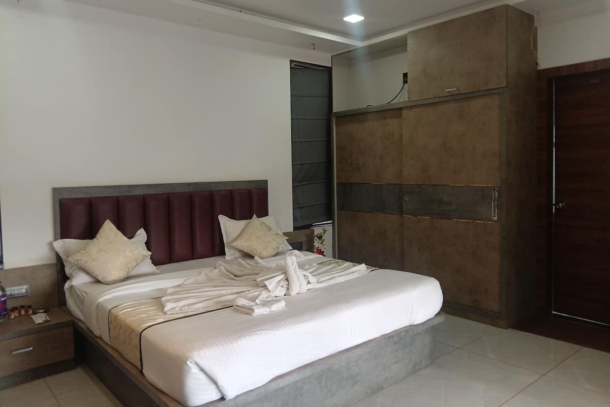 Quarto com cama, mesa de cabeceira, guarda-roupa e ventilador de teto.