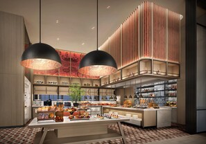 Cozinha moderna com ilha central, iluminação pendente e diversos alimentos à mostra.