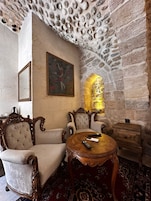 Quarto com parede de pedra, um quadro, um sofá, uma mesa e um armário de madeira.