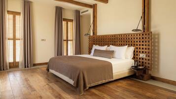 Quarto com estrutura de cama de madeira, mesa de cabeceira com abajur e janela com cortinas.