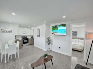 Um apartamento moderno com cozinha, sala de jantar e um quarto.