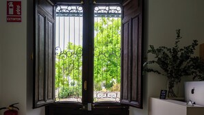 Uma porta com uma placa indicando 'SALIDA', que dá para uma área externa com vista para o verde.