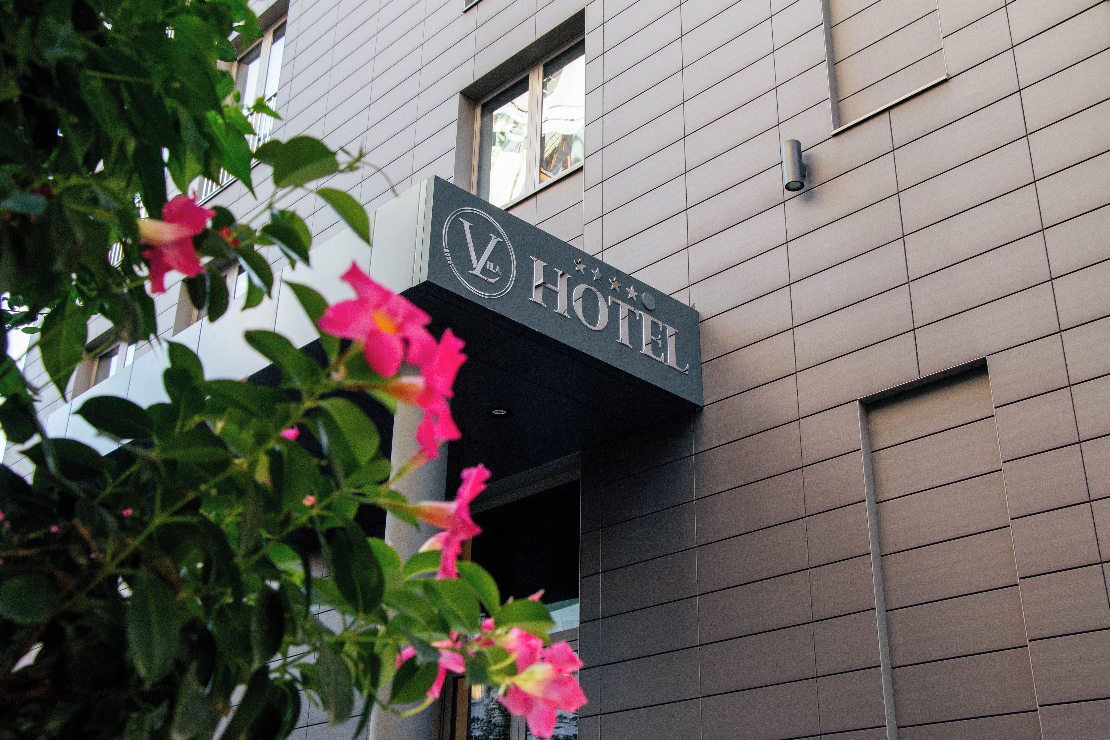 Placa de hotel com design moderno, exibindo um logotipo e a palavra 'HOTEL' em destaque.