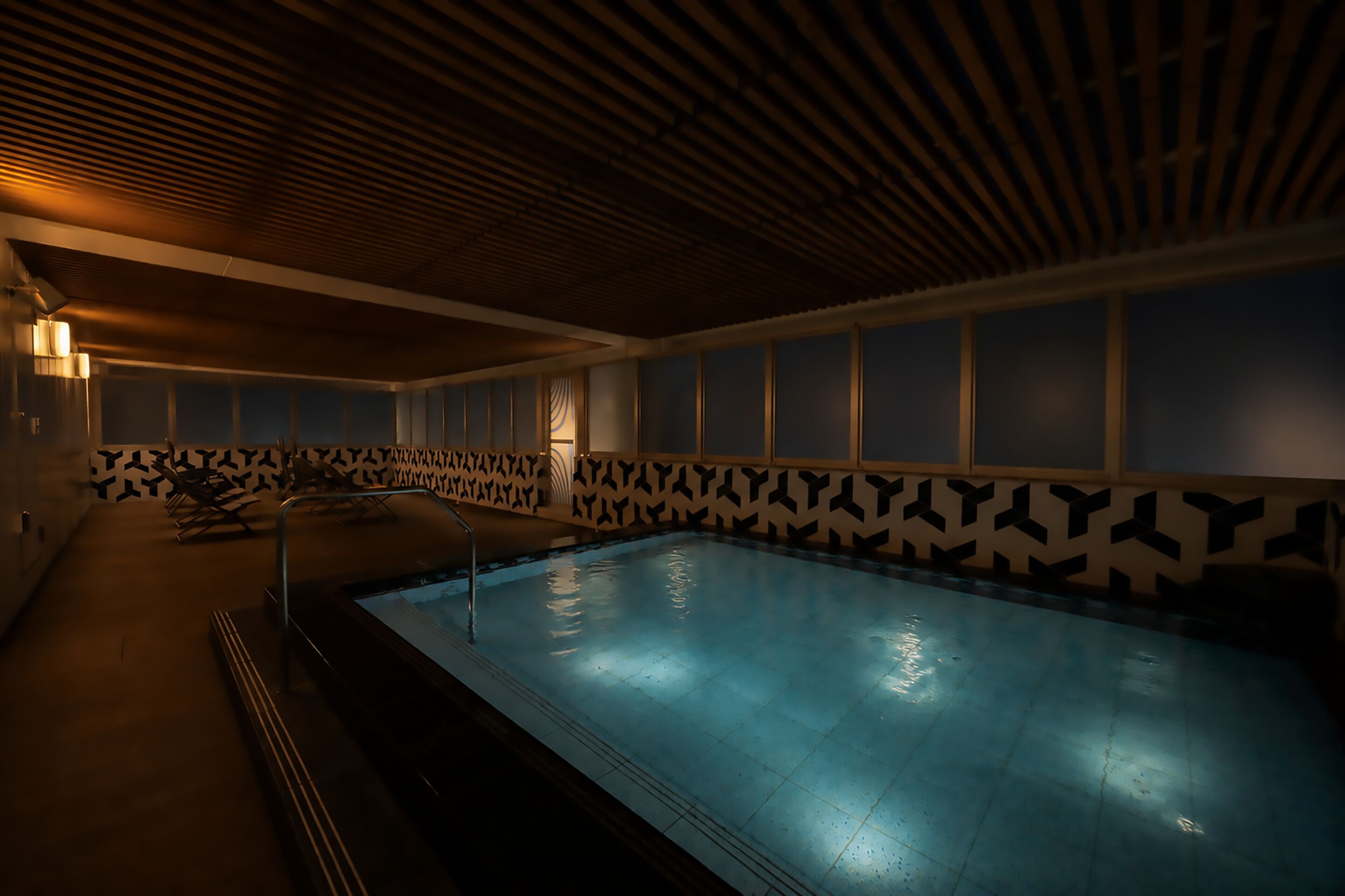 Piscina interna com parede e teto estampados.