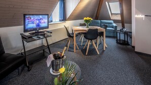 Quarto moderno estilo loft, com televisão, mesa de jantar e área de estar.