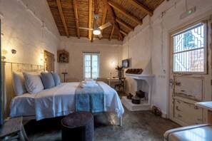 Quarto com cama, escrivaninha, cadeira, janela e ventilador de teto.