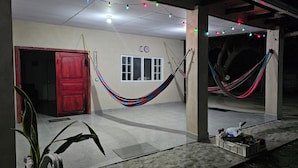 Um edifício com uma porta vermelha, uma janela com uma placa de boas-vindas e uma rede estendida entre dois pilares.