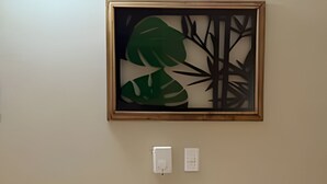 Uma cama com roupa de cama branca, cabeceira de madeira e uma obra de arte pendurada na parede.