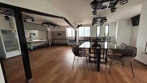 Cozinha espaçosa com área de refeições, apresentando uma mesa grande e cadeiras de vime.