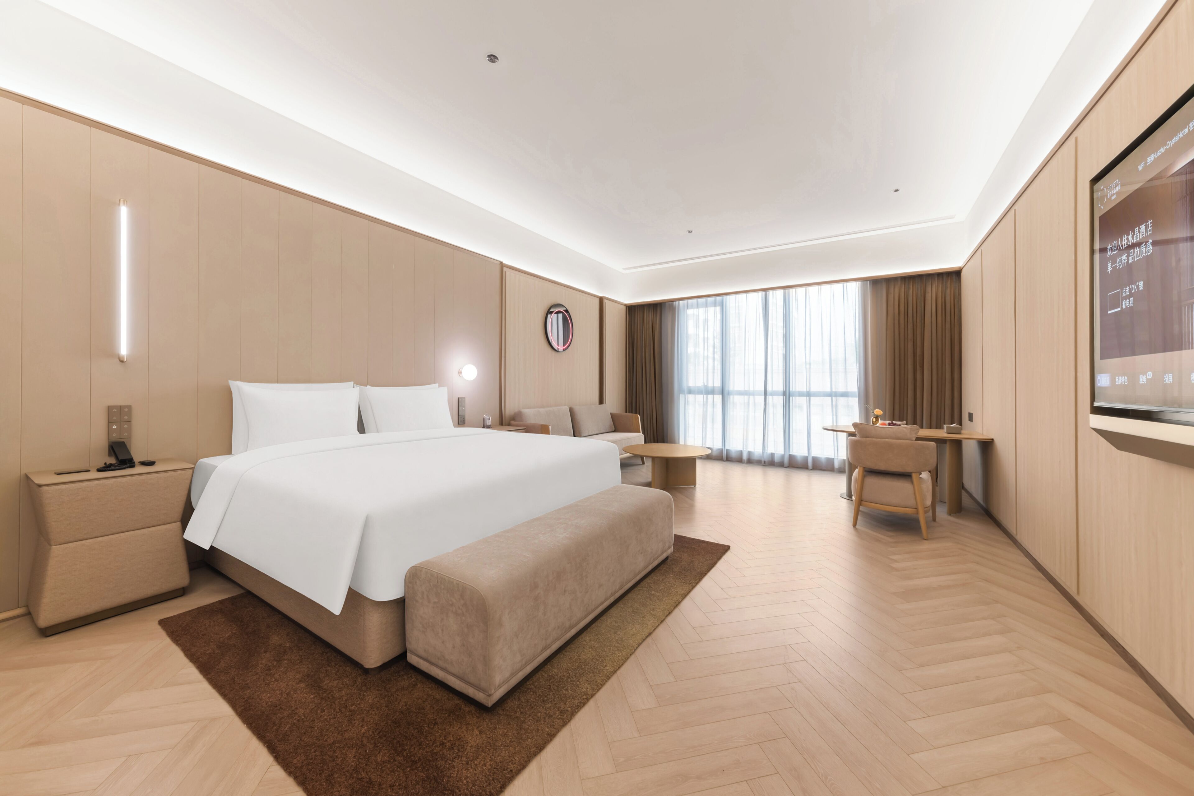 Quarto de hotel moderno com uma cama grande, mesas de cabeceira, escrivaninha e televisão.