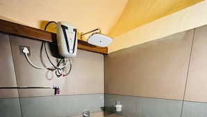 Casa de banho com sanita, bidé e lavatório, equipada com secador de mãos e um porta-toalhas.