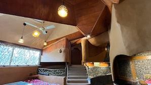 Quarto com cama, mesa, escada e um detalhe decorativo na parede.