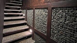 Uma escada com parede de treliça de metal e teto de madeira.