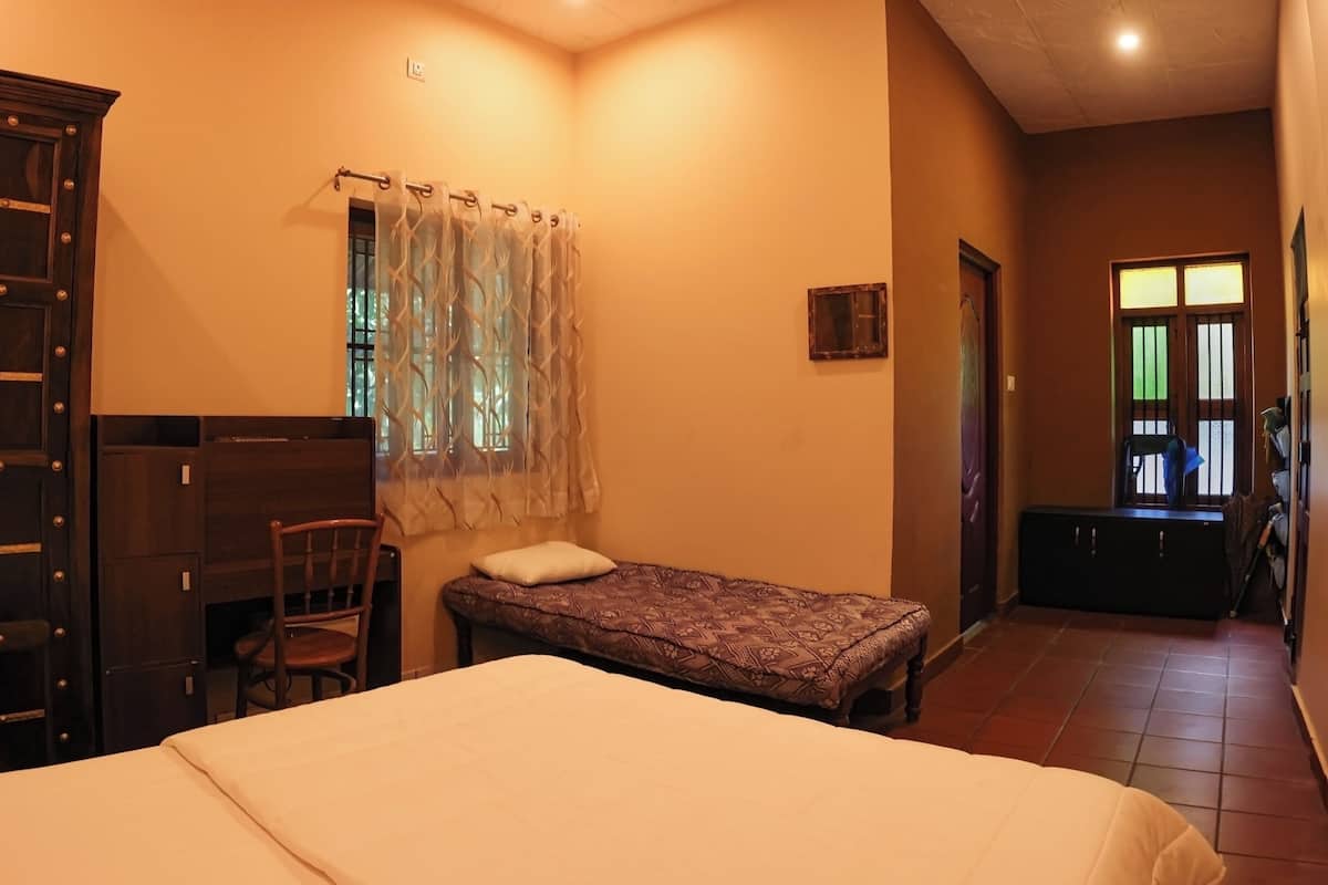 Quarto com cama, escrivaninha, cadeira, janela com cortinas e guarda-roupa.