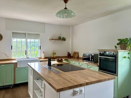 Uma cozinha com ilha central, forno embutido, micro-ondas e pia.