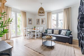 Uma sala de estar moderna com sofá, mesa de jantar, cadeiras e mesa de centro.