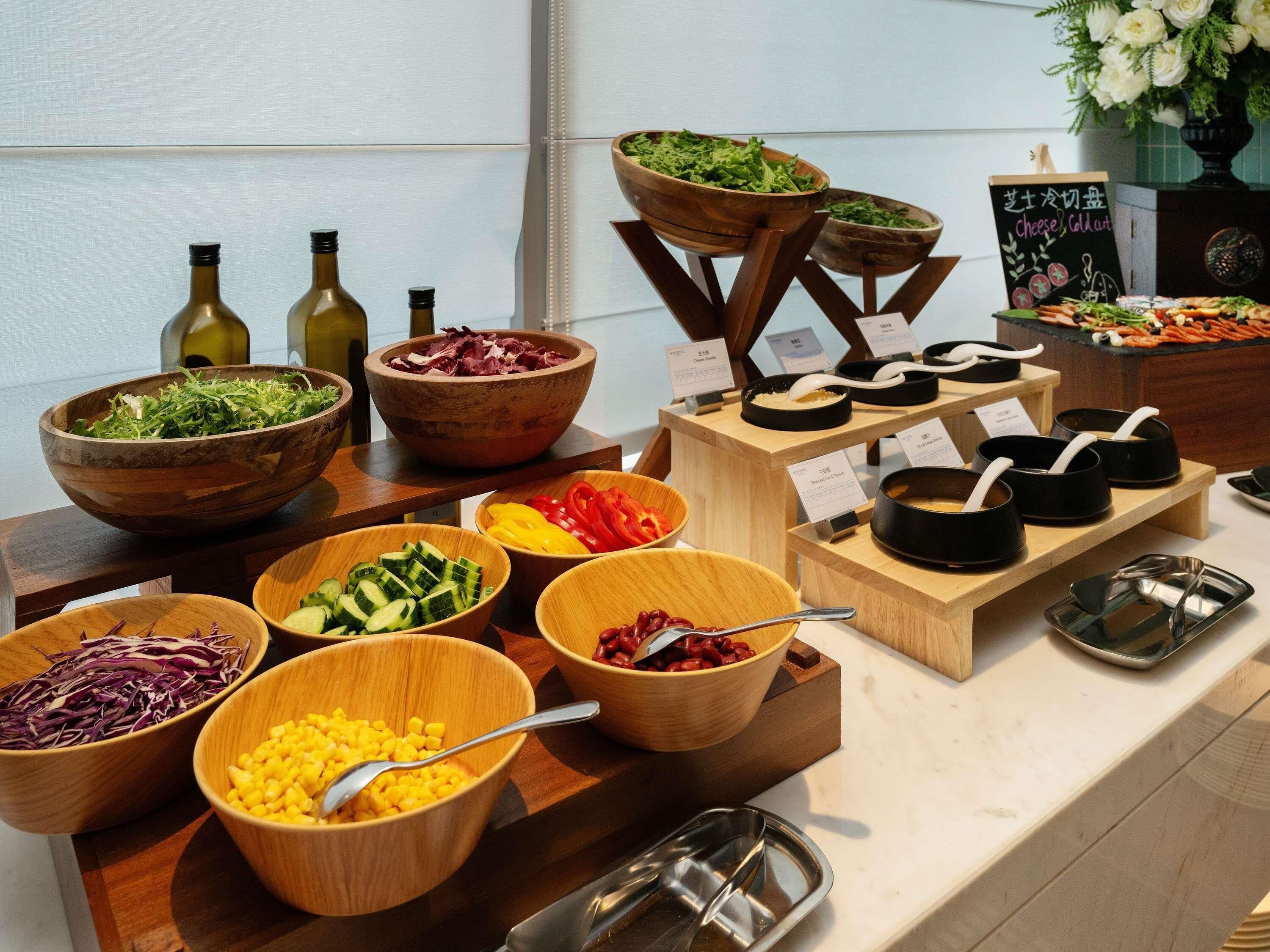 Um buffet com diversos alimentos e acompanhamentos.