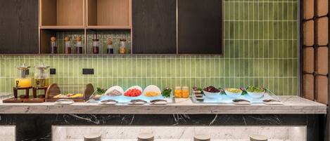 Cozinha com bancadas de mármore, armários de madeira e painel de azulejos verdes.