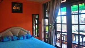 Quarto com cama, janela com cortinas e vista para o exterior.