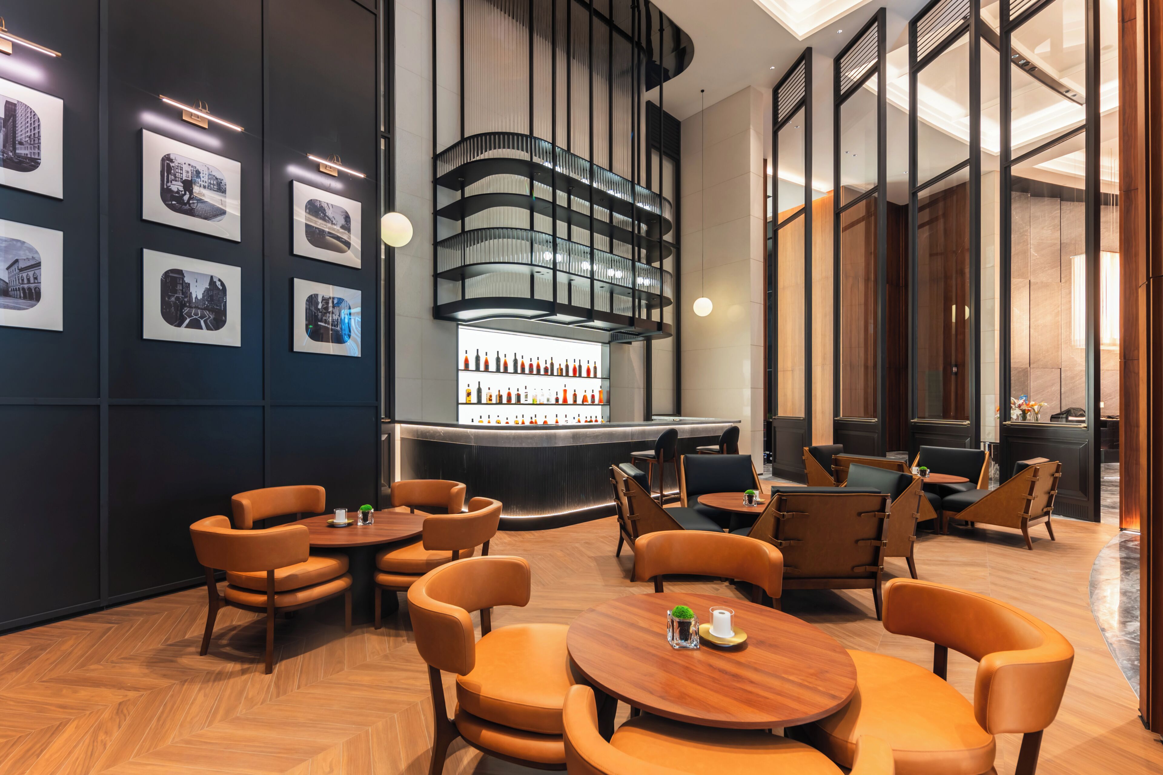Um interior moderno com área de bar, assentos e quadros nas paredes.