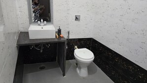 Um banheiro com pia branca, vaso sanitário e espelho sobre a pia.