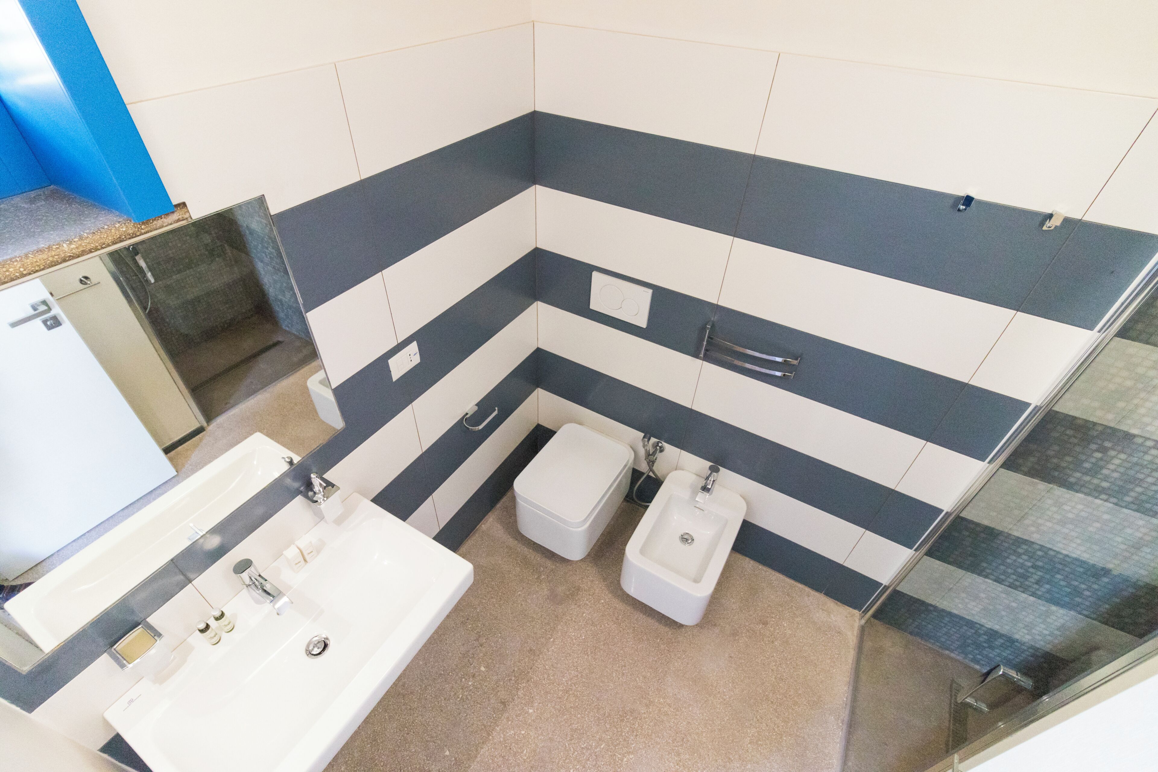 Casa de banho com uma sanita branca, duas casas de banho e um bidé.