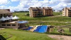 Um complexo residencial com vários edifícios, piscina e área ajardinada.