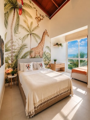 Quarto com uma cama grande, vista para o oceano, um mural de girafa e decoração tropical.
