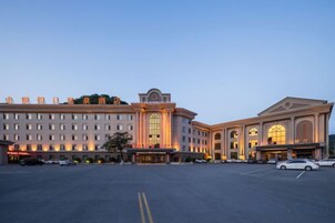 Um hotel grande com um pátio central, vários andares e estilo arquitetônico clássico.