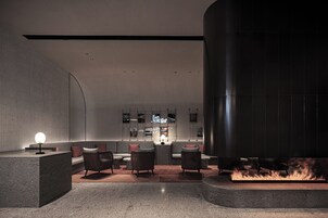 Uma área de estar moderna com lareira, assentos e balcão de recepção.