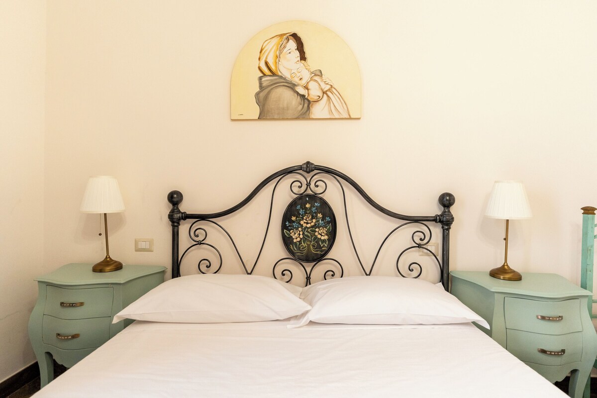 Uma cama com cabeceira, duas mesas de cabeceira e um quadro pendurado na parede.