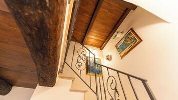 Uma escada de madeira com corrimão de metal e um quadro na parede.