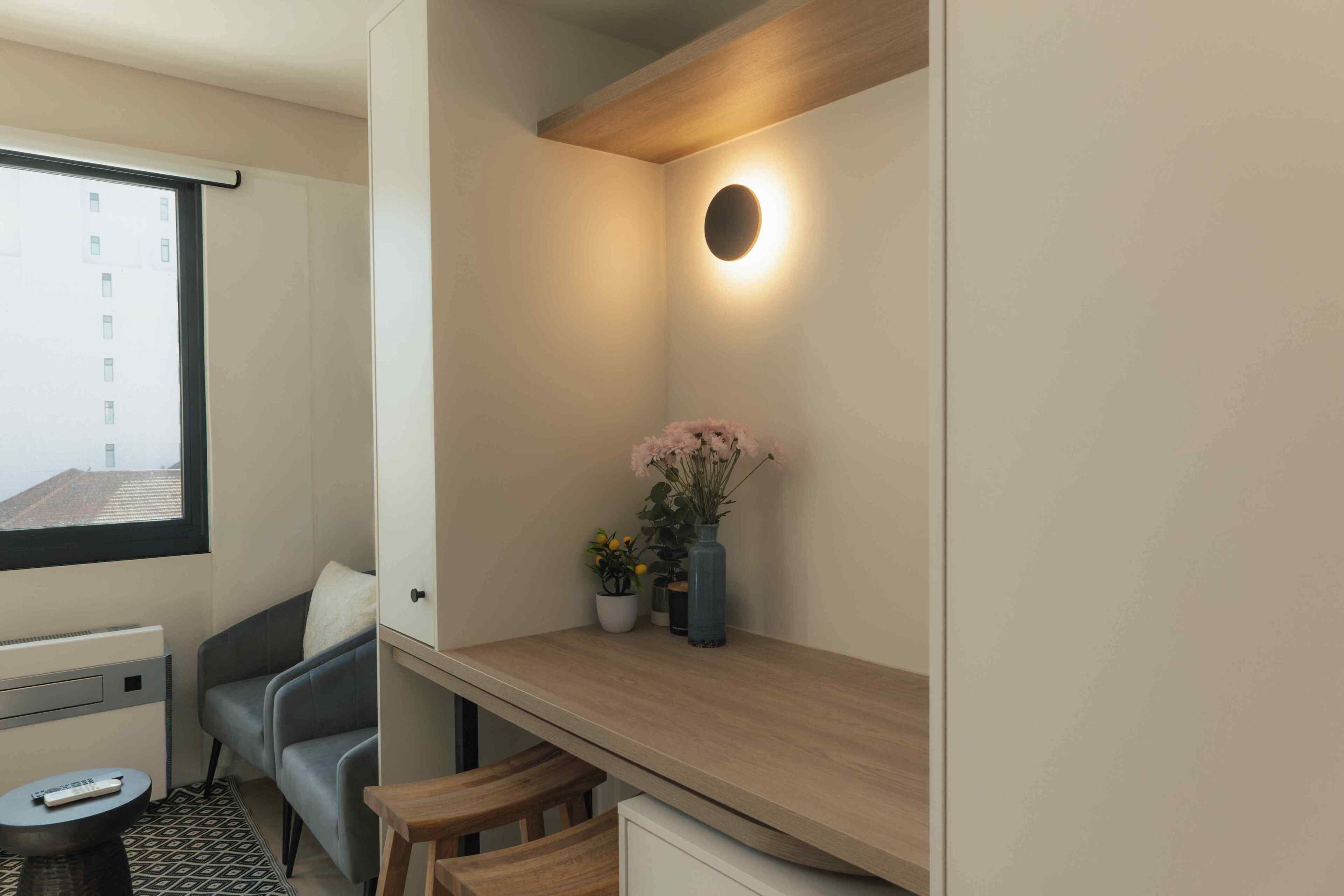 Um espaço compacto com cozinha compacta, área de estar e uma mesa pequena.