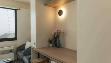 Um espaço compacto com cozinha compacta, área de estar e uma mesa pequena.