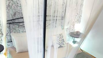 Um quarto com uma cama, uma cadeira e uma mesa.