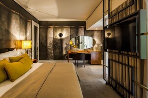 Quarto moderno com cama, escrivaninha e um espelho grande.