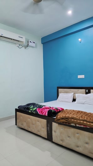 Quarto com uma cama, ar condicionado e parede azul.