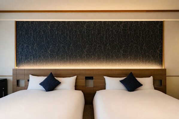Quarto de hotel com duas camas, uma obra de arte grande fixada na parede e cabeceira de madeira.