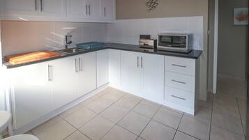 Apartamento básico, vista parcial para o oceano | Cozinha privada | Geladeira grande, micro-ondas, fogão, cooktop