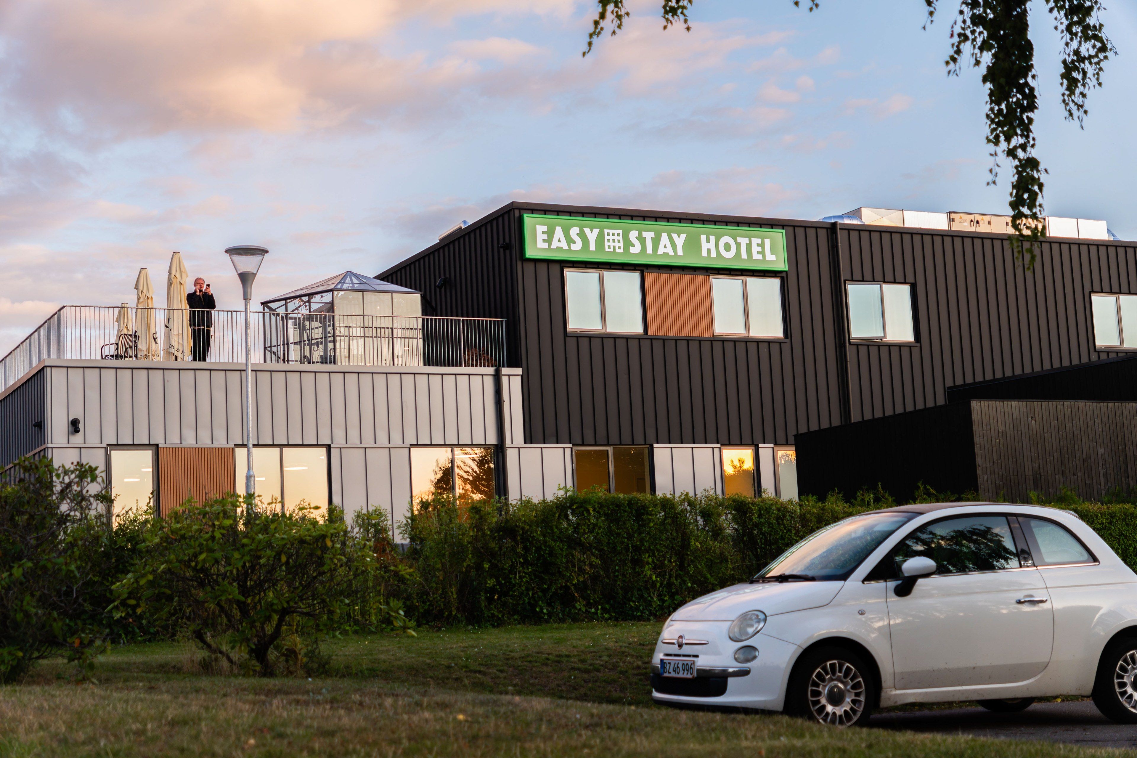 Um edifício moderno com uma placa indicando 'EASY STAY HOTEL'.