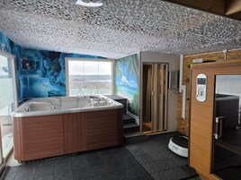 Quarto com hidromassagem, uma janela ampla com vista, uma porta e um teto texturizado.