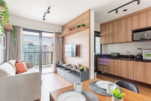 Um apartamento moderno com área de jantar, cozinha e varanda com vista para a cidade.