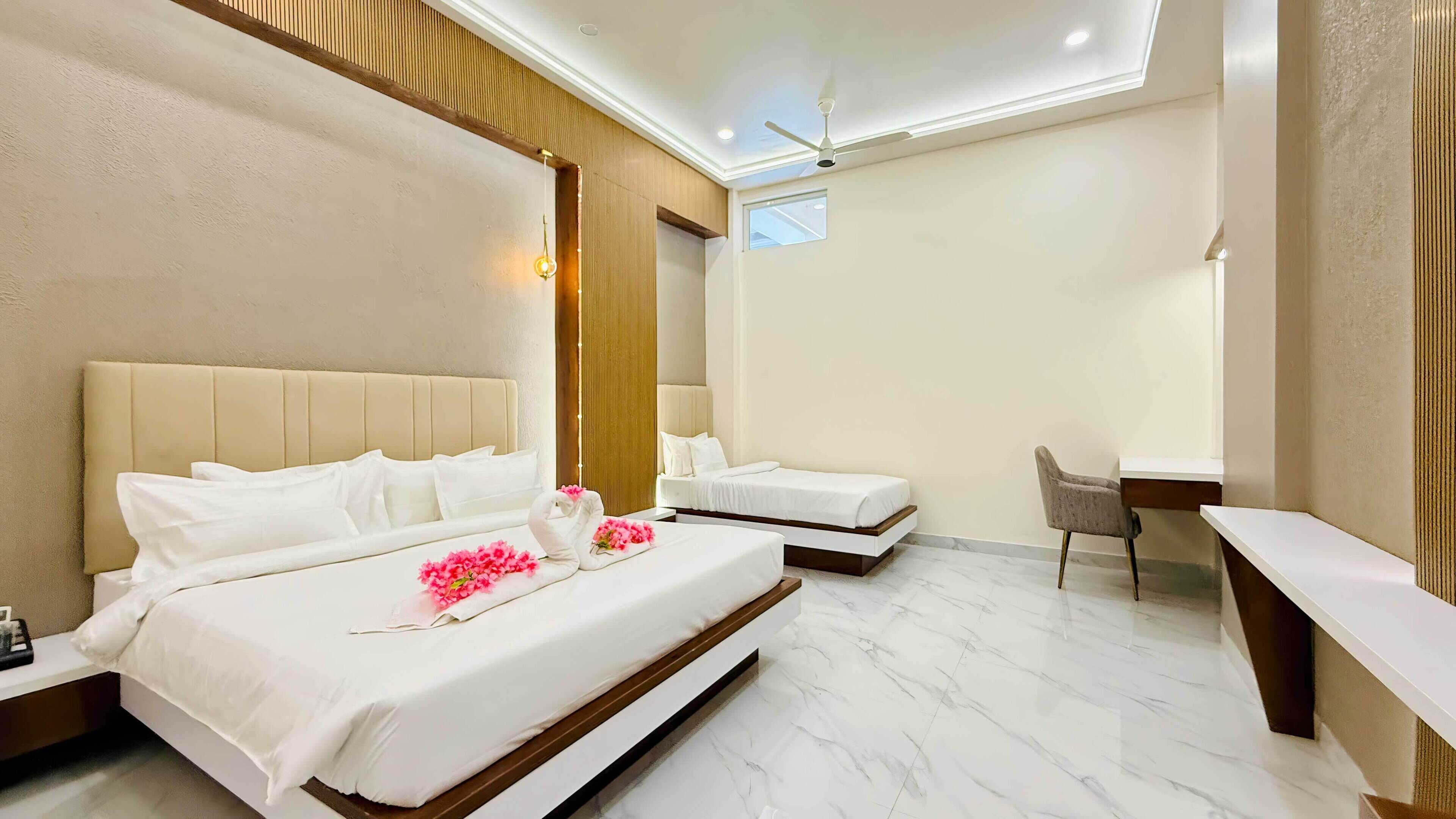 Quarto de hotel com duas camas, uma escrivaninha e uma cadeira.