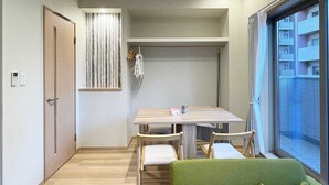 Espaço compacto com área de jantar, sofá e janela com vista para edifícios.