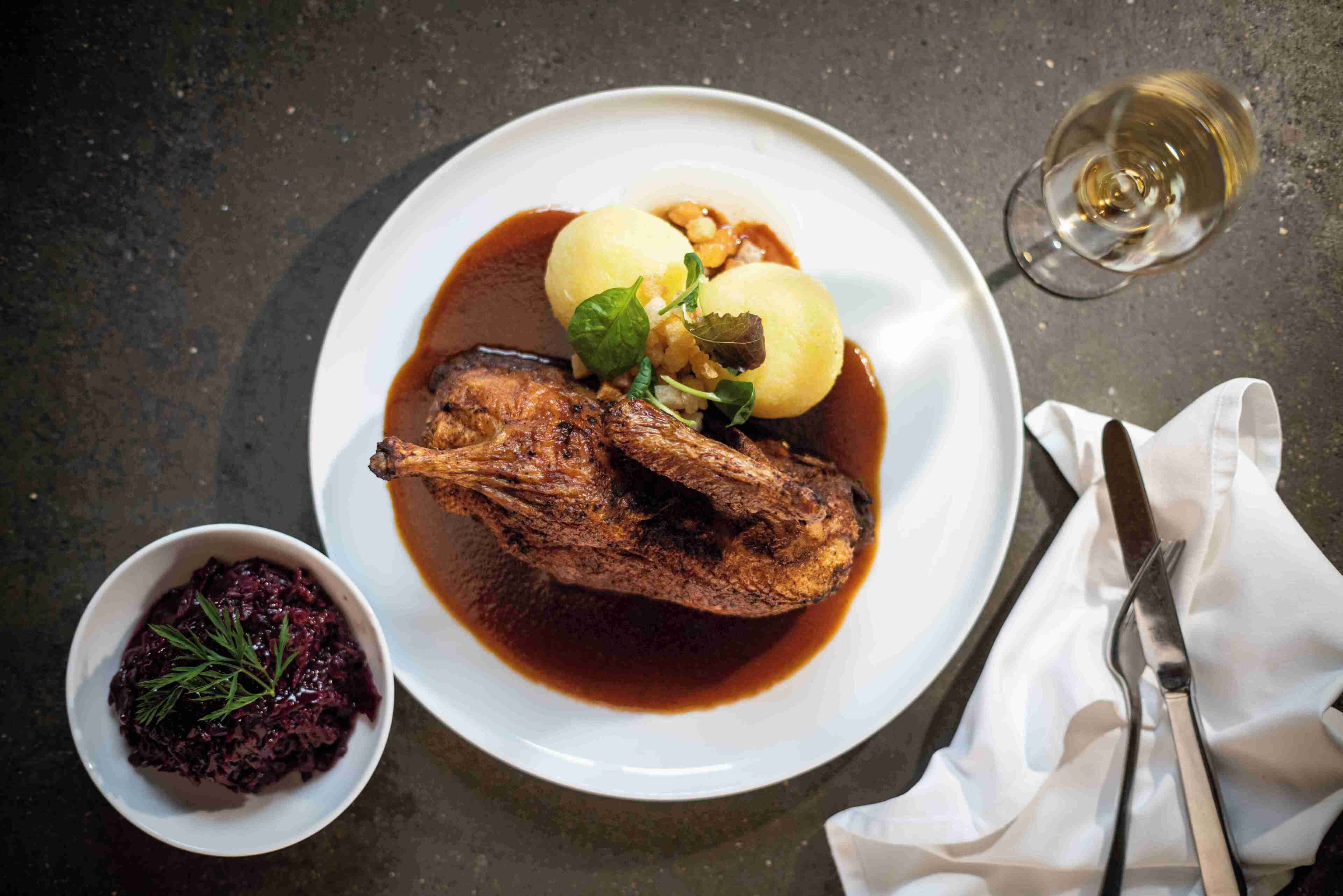 Um prato de comida com um copo de vinho e um guardanapo.