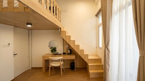 Um quarto com escrivaninha de madeira, cadeira e escada.