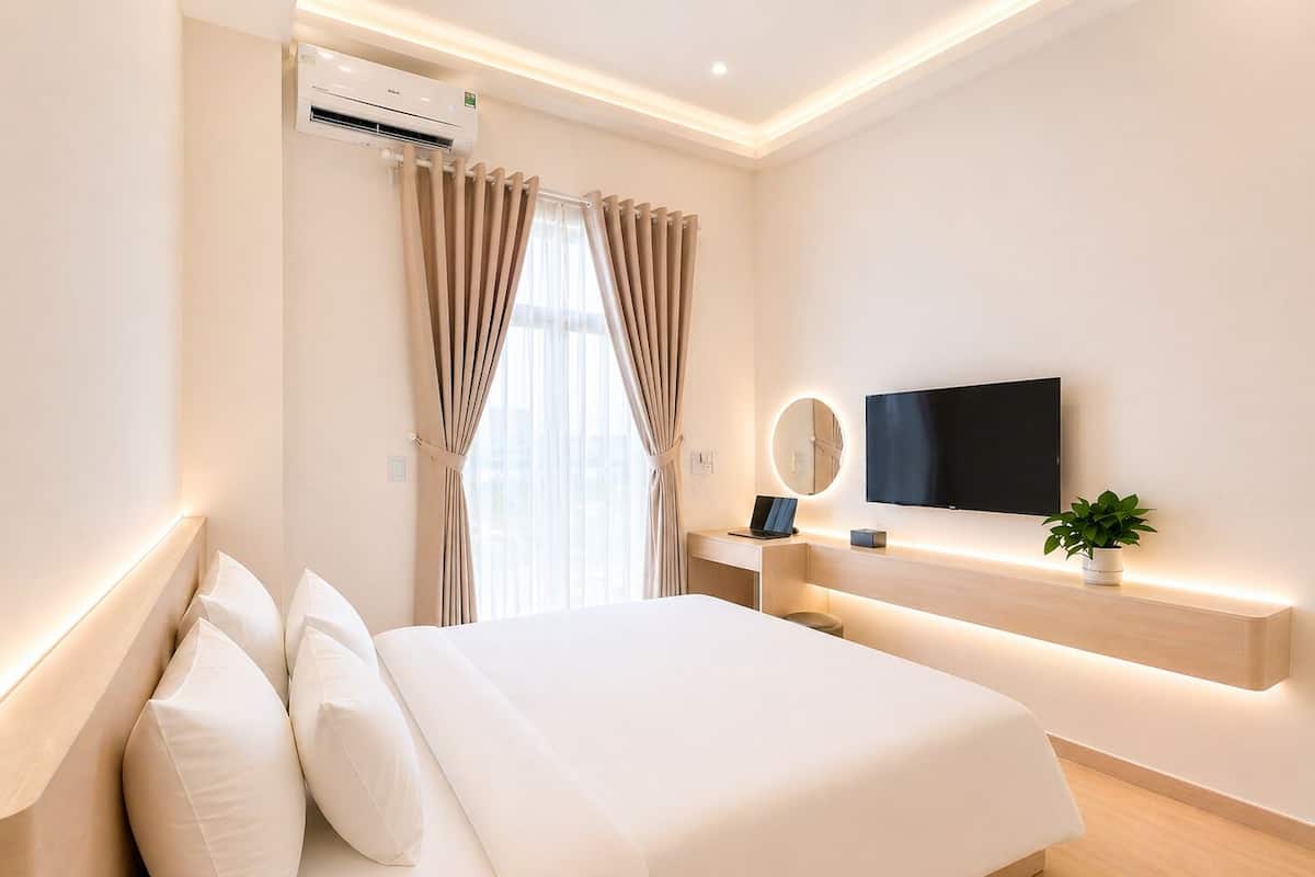 Quarto de hotel moderno com cama, televisão, mesa de cabeceira e ar condicionado.