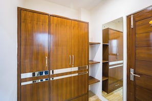 Um guarda-roupa de madeira com duas portas, um espelho e uma prateleira.